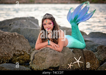 Tween mermaid on rocks Stock Photo - Alamy