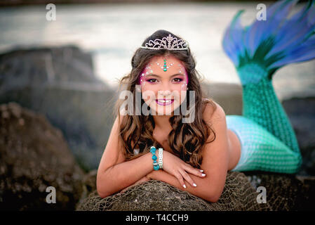 Tween mermaid on rocks Stock Photo - Alamy