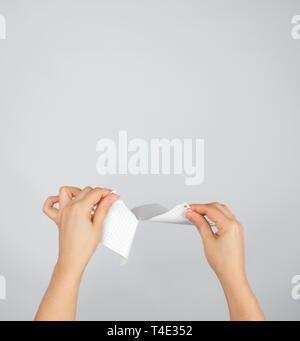 Female hands tearing a sheet of paper, closeup Stock Photo - Alamy