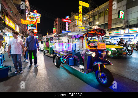 BANGKOK, THAILAND - MARCH 2019: tuk-tuk taxi driver at China town night market looking into the ...