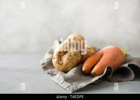 Ugly organic abnormal vegetables carrot and potatoes. Space for text ...