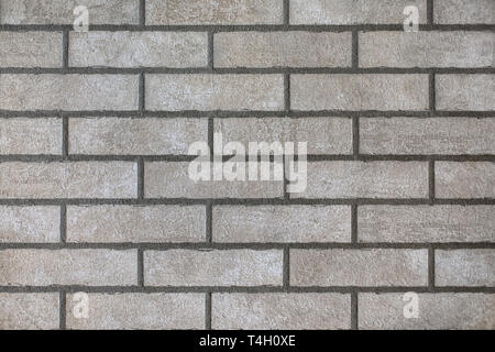 Closeup of modern neutral grey brick wall with dark seams. For pattern ...