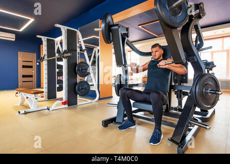 Portrait of sportive man pumping the press with fitness ball on rug ...