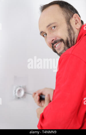 Professional electrician installing sockets using a screwdriver: home ...