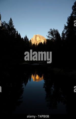 HALF DOME is reflected in the MERCED RIVER during the fall season ...