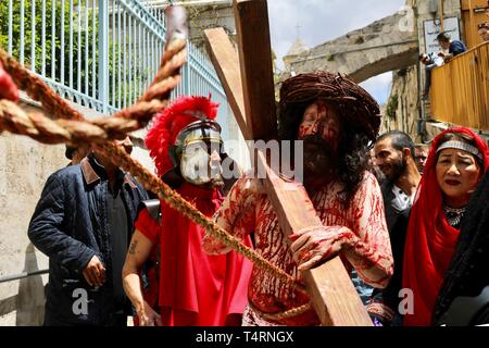 Jerusalem. 19th Apr, 2019. A worshipper holds a cross as he re-enacts ...