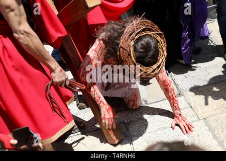 Jerusalem. 19th Apr, 2019. A worshipper holds a cross as he re-enacts ...