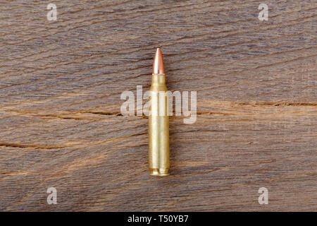 Close-up of rifle bulet on old wood desk Stock Photo - Alamy