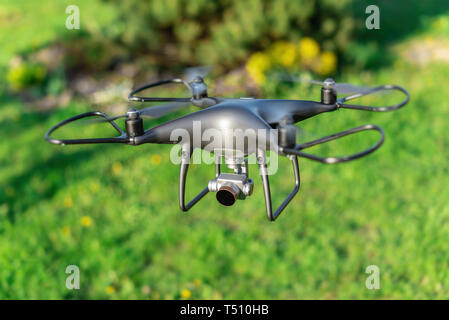 Dark drone flying through the air in the sun Stock Photo - Alamy