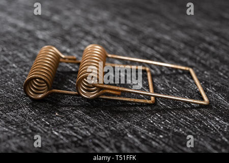 side view two pieces rusty springs on dark background Stock Photo - Alamy
