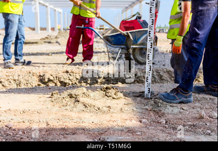Construction worker is using tool to realign, correct measure or level ...