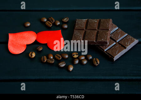 Coffee beans, chocolate and red hearts on a natural wooden background ...