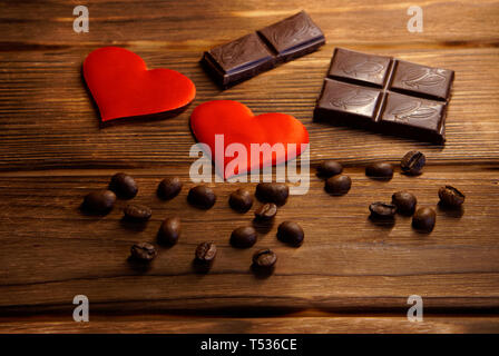 Coffee beans, chocolate and red hearts on a natural wooden background ...