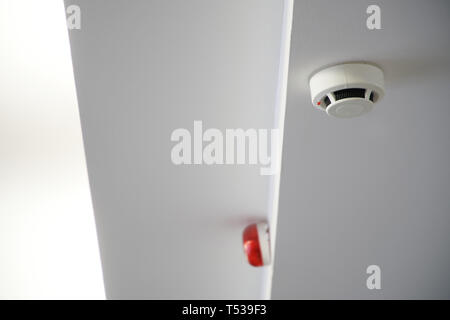 ceiling mounted white fire detector used to activate warning systems ...
