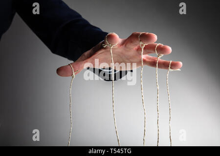Manipulation concept. Puppet master hands controlling the stock market ...