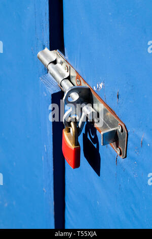 padlock and bolt fixed to door and frame providing security to building ...
