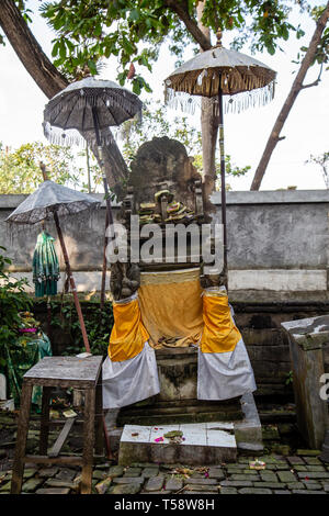 Traditional offerings and a statue on an altar with a misty volcano ...