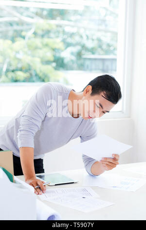 Asian software engineer working with user interface on computer screen to develop new security ...