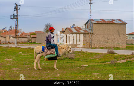 Turkish Man Riding donkey on road in Cappadocia region of Turkey Stock ...