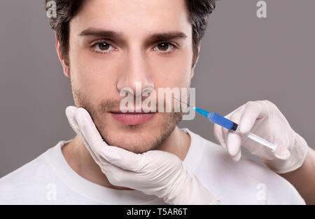 Plastic surgery concept. Man receiving injection in his face. Trendy ...