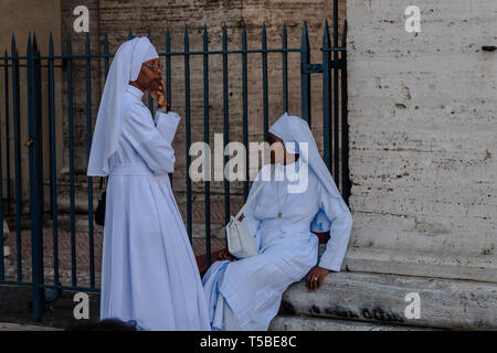 Two nuns in white robes walk across the Piazza Navona in Rome, Italy ...