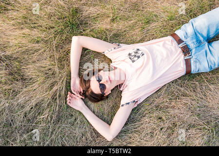 Girl laying on grass in field of flowers Stock Photo - Alamy