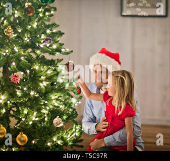 Happy father and daughter decorating together the christmas tree ...