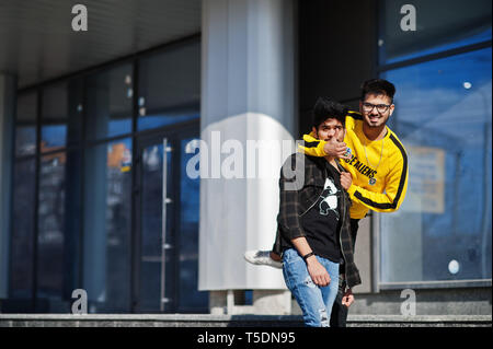 Two asian guys posed against new modern building Stock Photo - Alamy