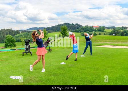 Golf players practising on drivingrange Stock Photo - Alamy