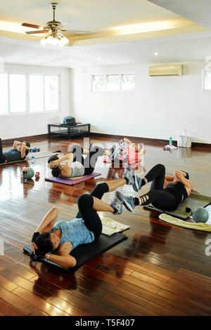 Women doing abs exercise in gym, front view Stock Photo - Alamy