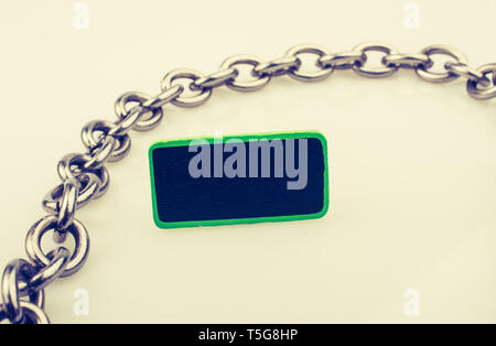 Small green sided black noticeboard surrounded by chain on a white ...