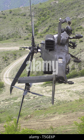 An AH-64 Apache helicopter flies overhead during an aerial gunnery ...