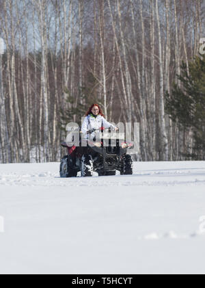 Woman riding snowmobile in snowy alps during winter Stock Photo ...