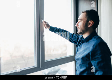 Man is opening the window at home to refresh the room Stock Photo - Alamy