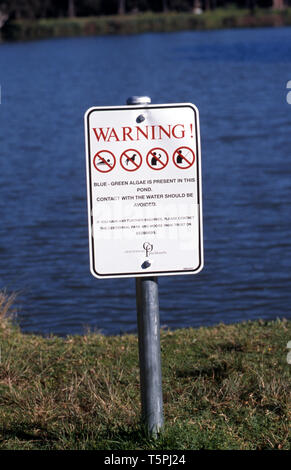 Pond warning signs in a park on a wooden post advising of deep water ...
