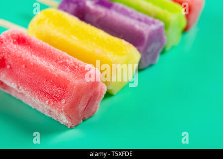 multi-color popsicles line up on green background with copy space Stock ...