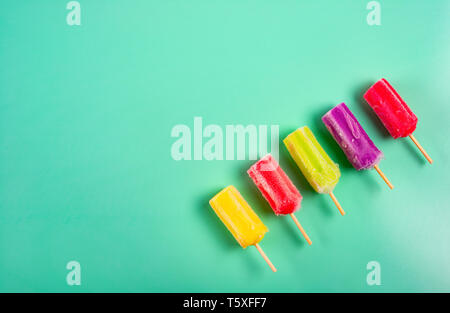multi-color popsicles line up on green background with copy space Stock ...