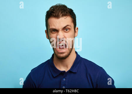 Furious, enraged man with grumpy grimace on his face,with mouth opened ...