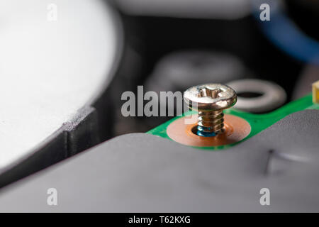 A shiny metal bolt securing the processor board, unscrewed in half ...
