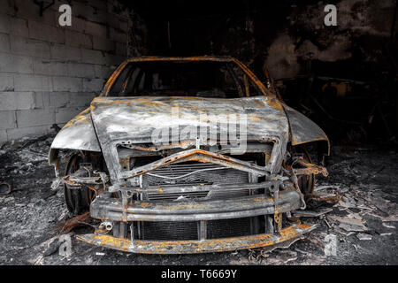 Close up photo of a burned out cars in garage after fire for grunge ...