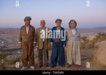 Kurdish men wearing traditional clothes take in the view of Dohuk ...
