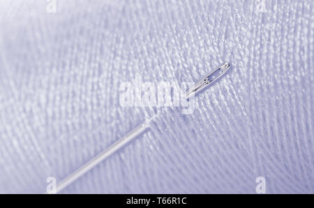 Grey threat with needle Stock Photo - Alamy