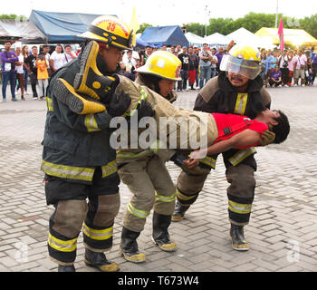 Participating firefighters are seen carrying a wounded patient during a ...
