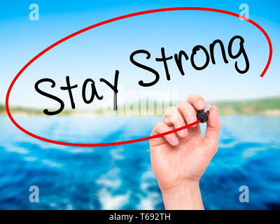 Man Hand writing Stay Strong with black marker on visual screen ...