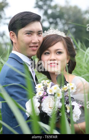 Happy luxury bride and groom looking at each other standing near window ...
