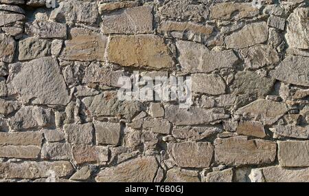 Old wall made of uneven natural stones. Abstract construction ...