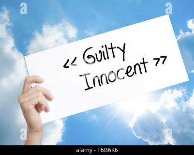 Guilty - Innocent Sign on white paper. Man Hand Holding Paper with text ...