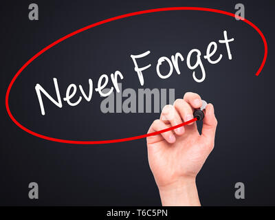 Man Hand writing Never Forget with black marker on visual screen ...