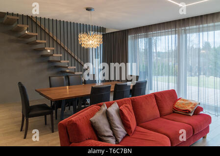 Comfortable sofa and dining table with soft cushions located in ...