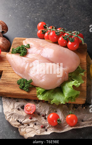Composition of raw fresh chicken fillet placed on black surface near ...